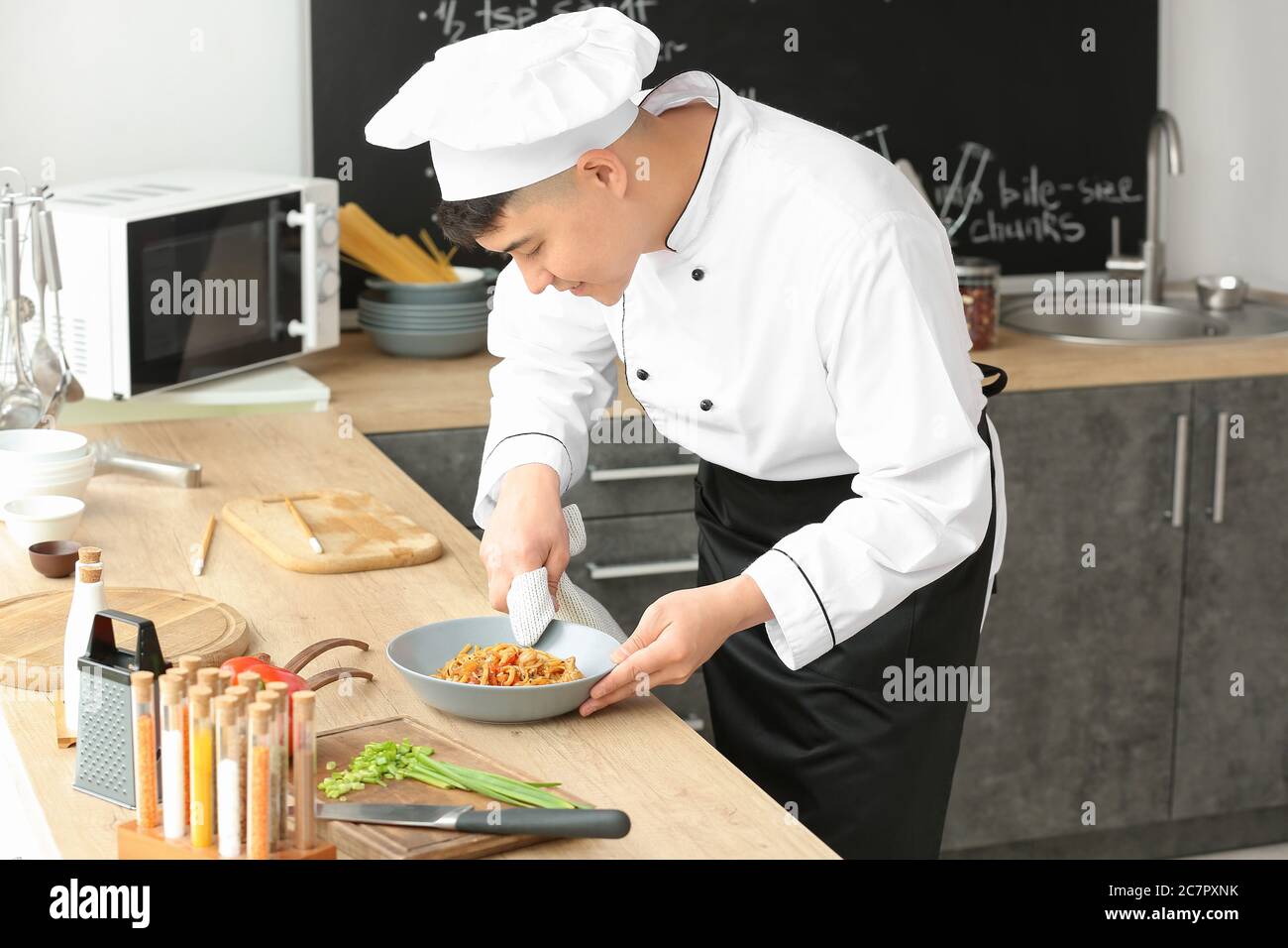 Handsome Asian chef cooking in kitchen Stock Photo - Alamy