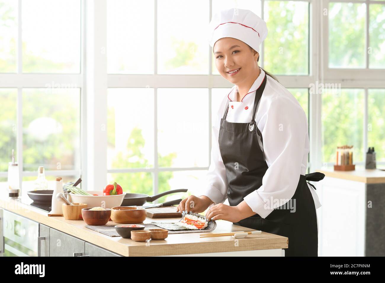 Beautiful Asian chef cooking in kitchen Stock Photo - Alamy