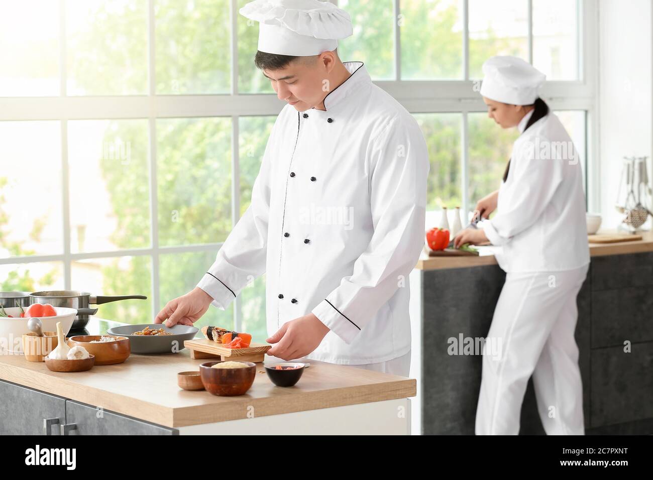 Asian chefs cooking together in kitchen Stock Photo - Alamy
