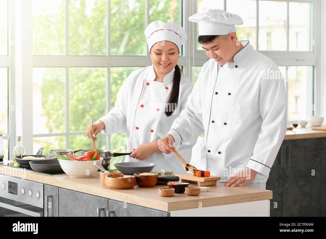 Asian chefs cooking together in kitchen Stock Photo - Alamy