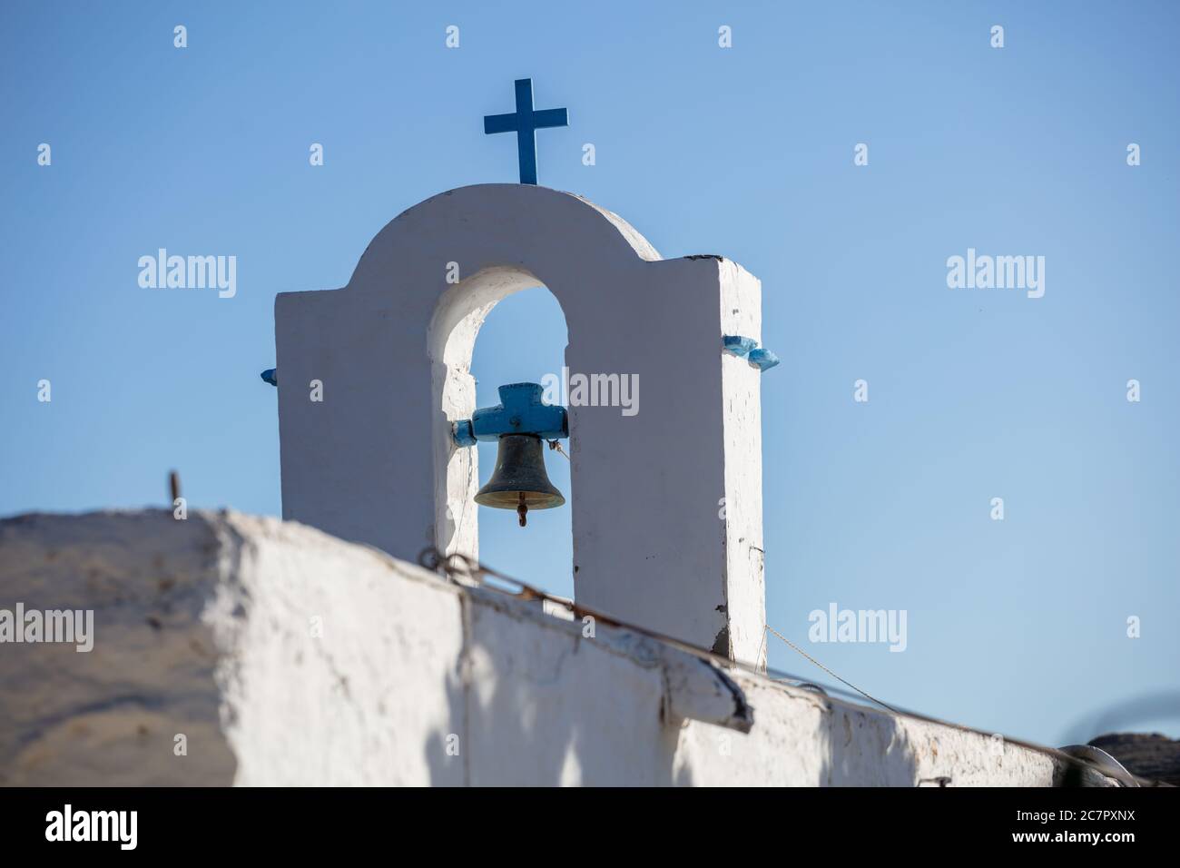 Small church belfry detail, whitewashed, mountains and blue sky ...