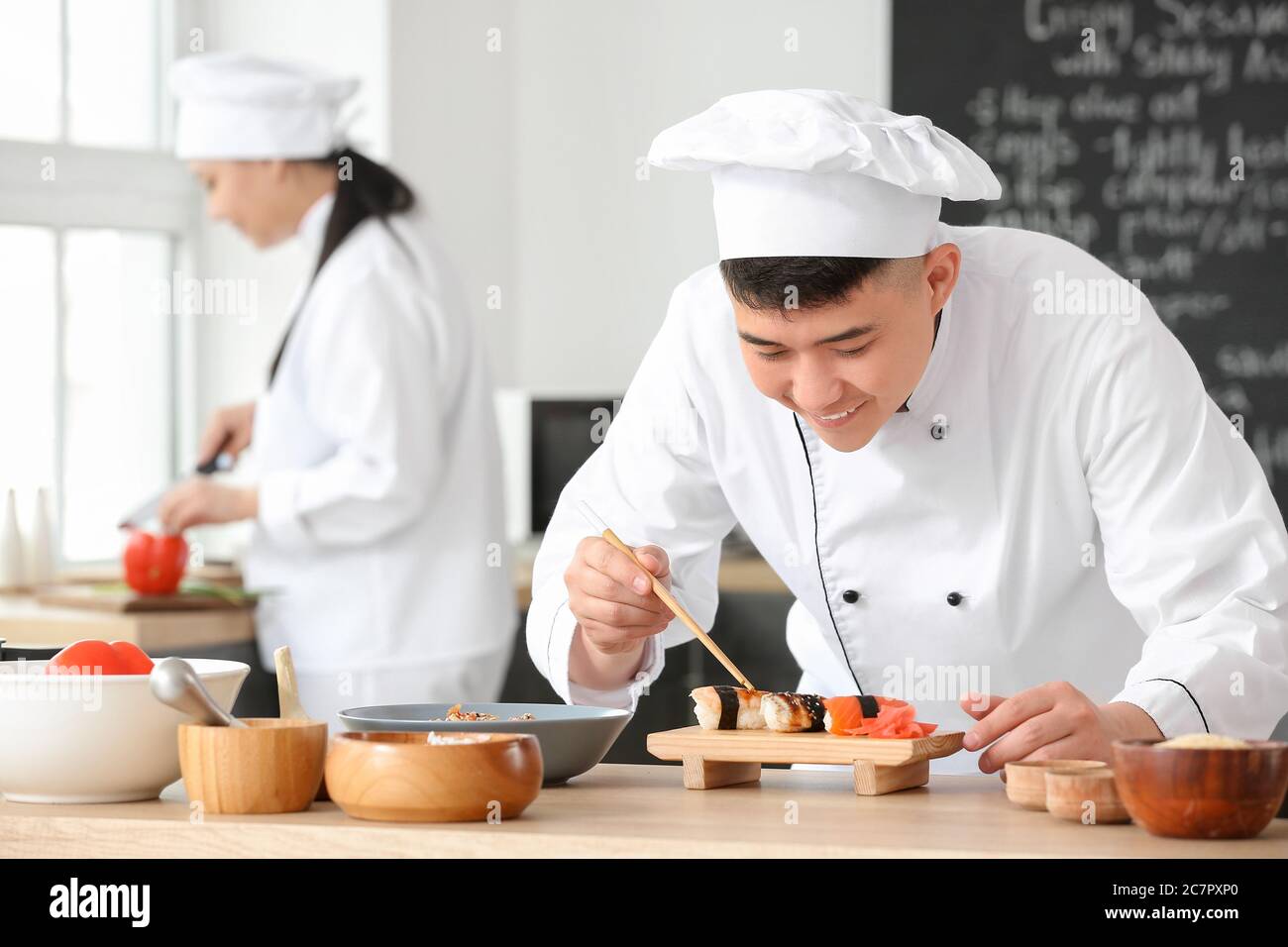 Handsome Asian chef cooking in kitchen Stock Photo - Alamy