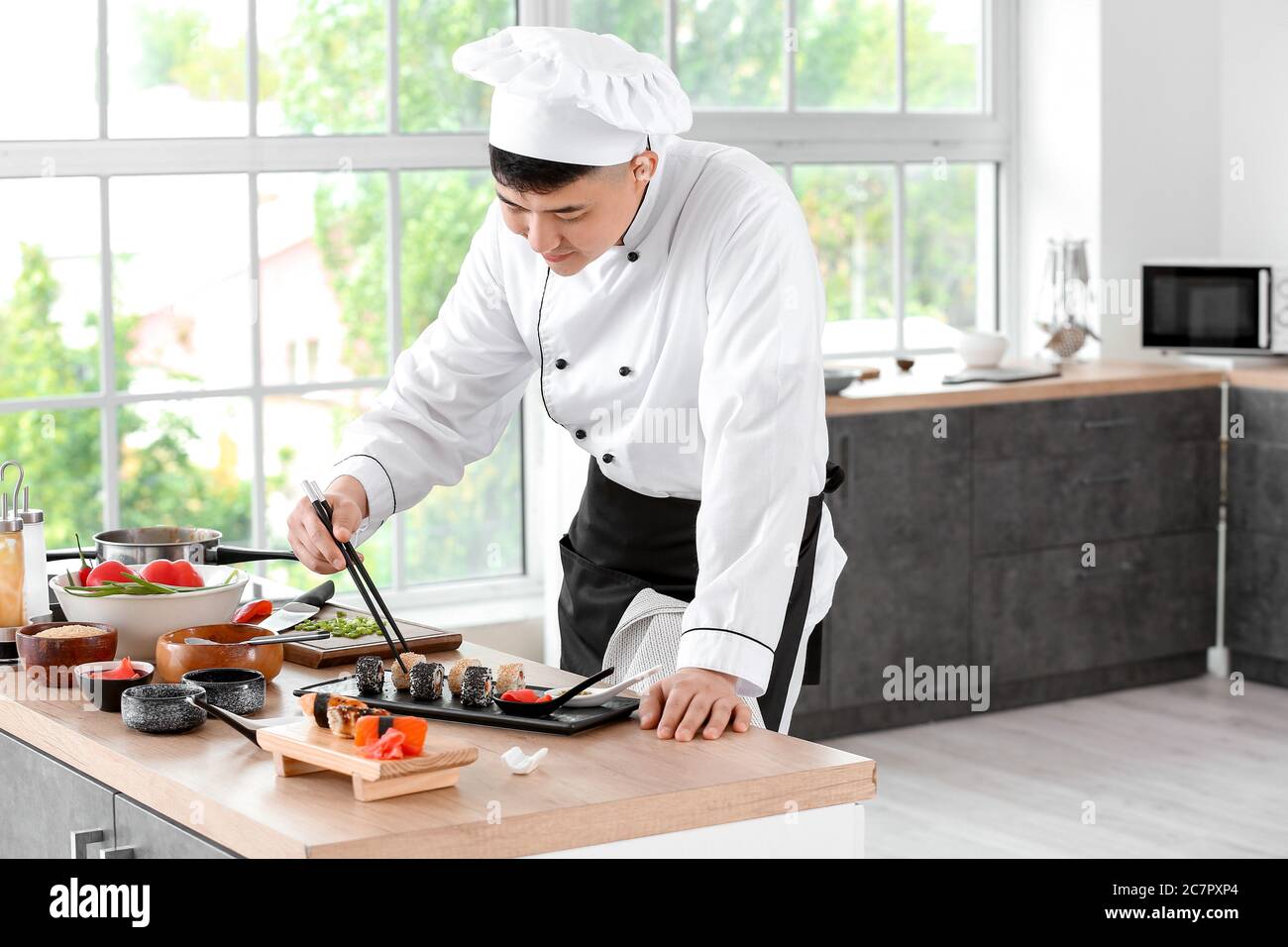 Handsome Asian chef cooking in kitchen Stock Photo - Alamy