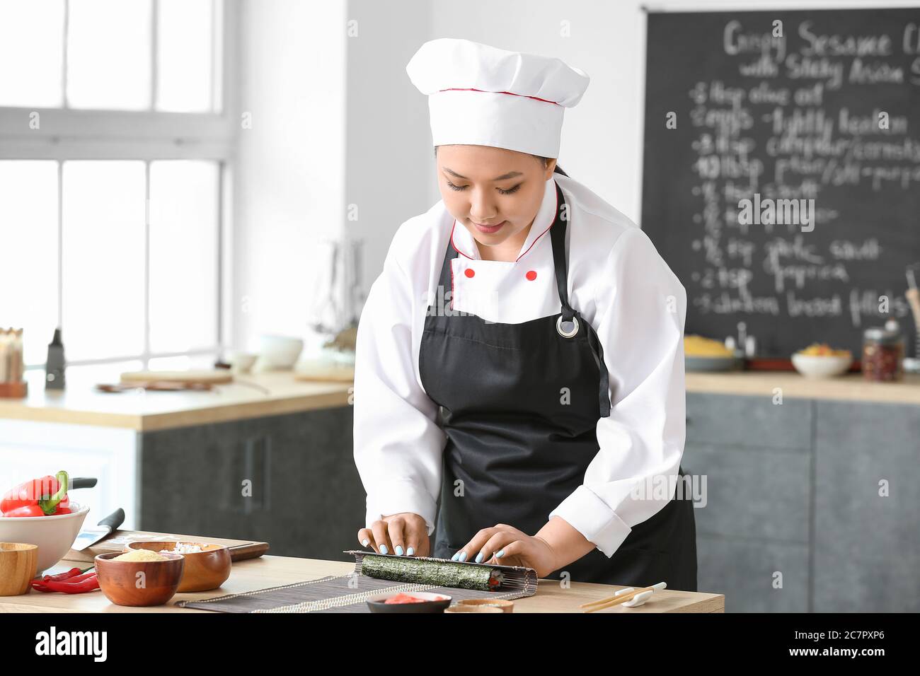 Beautiful Asian chef cooking in kitchen Stock Photo - Alamy