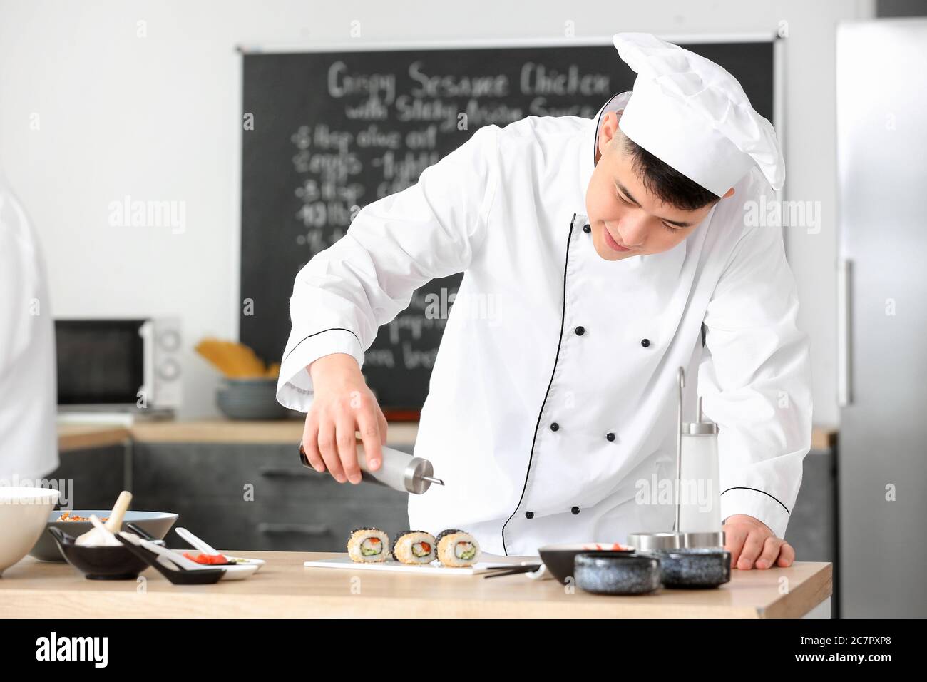 Handsome Asian chef cooking in kitchen Stock Photo - Alamy