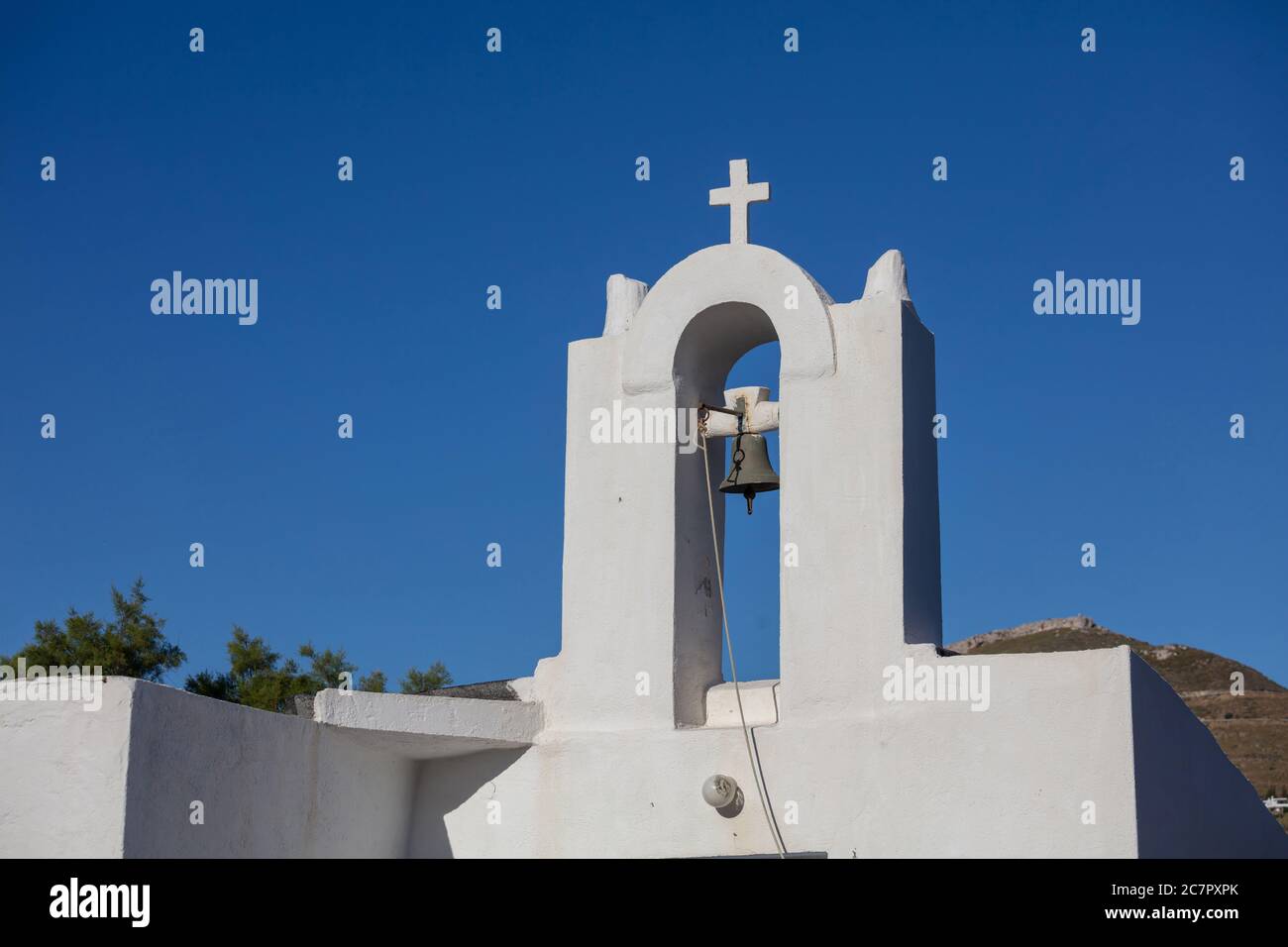 Small church belfry detail, whitewashed, mountains and blue sky ...