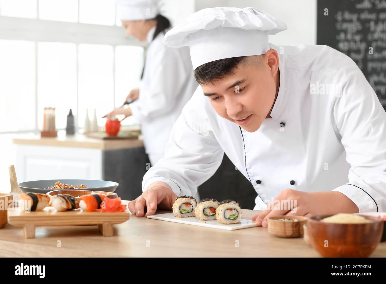 Handsome Asian chef cooking in kitchen Stock Photo - Alamy