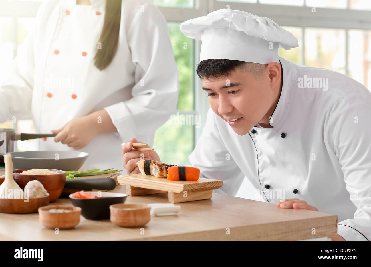 Handsome Asian chef cooking in kitchen Stock Photo - Alamy