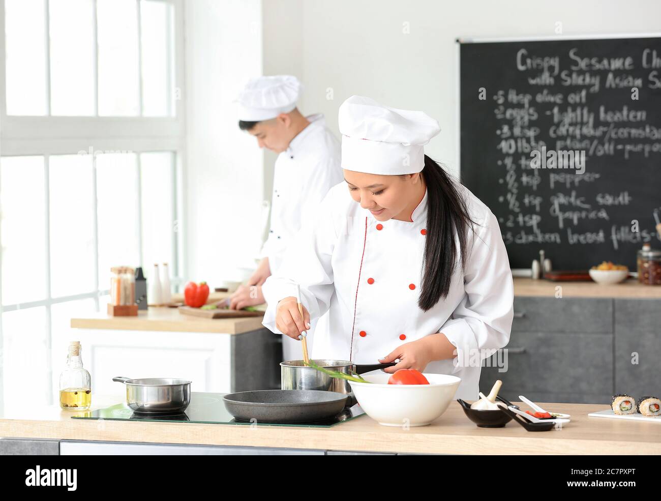 Beautiful Asian chef cooking in kitchen Stock Photo - Alamy
