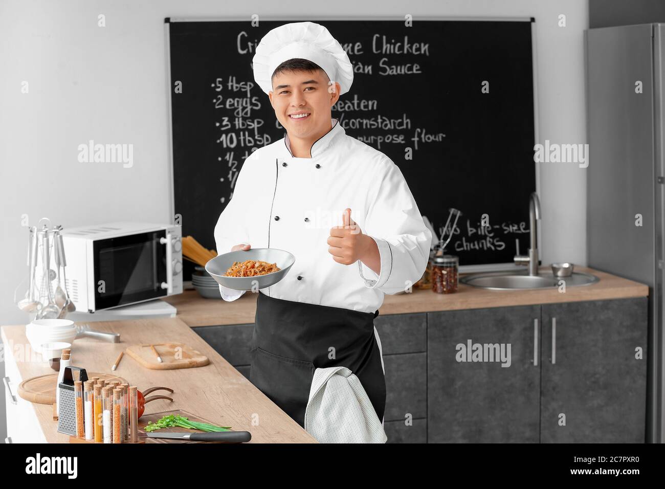 Handsome Asian chef cooking in kitchen Stock Photo - Alamy