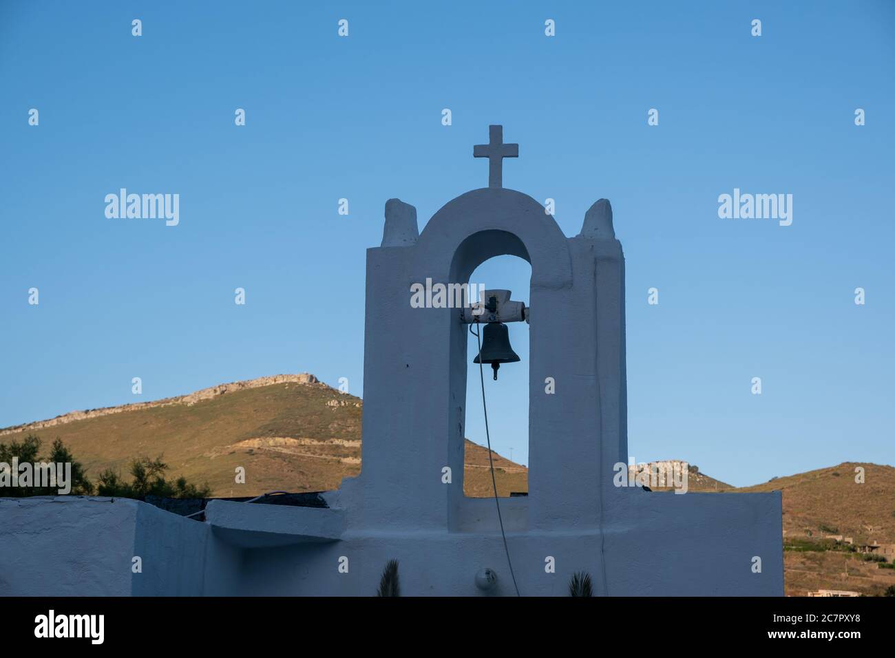Small church belfry detail, whitewashed, mountains and blue sky ...