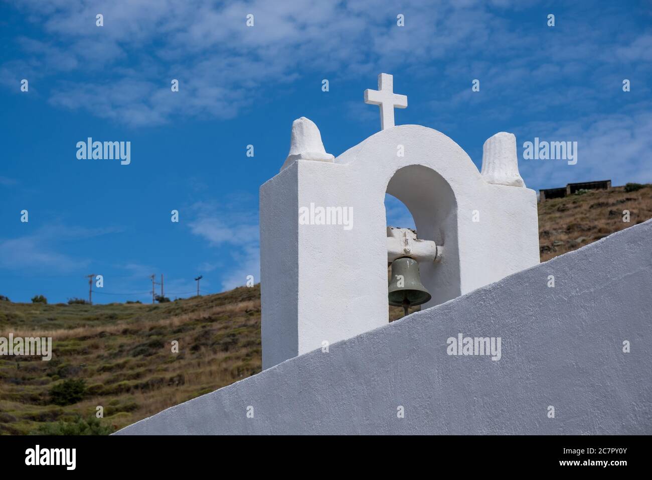Small church belfry detail, whitewashed, mountains and blue sky ...