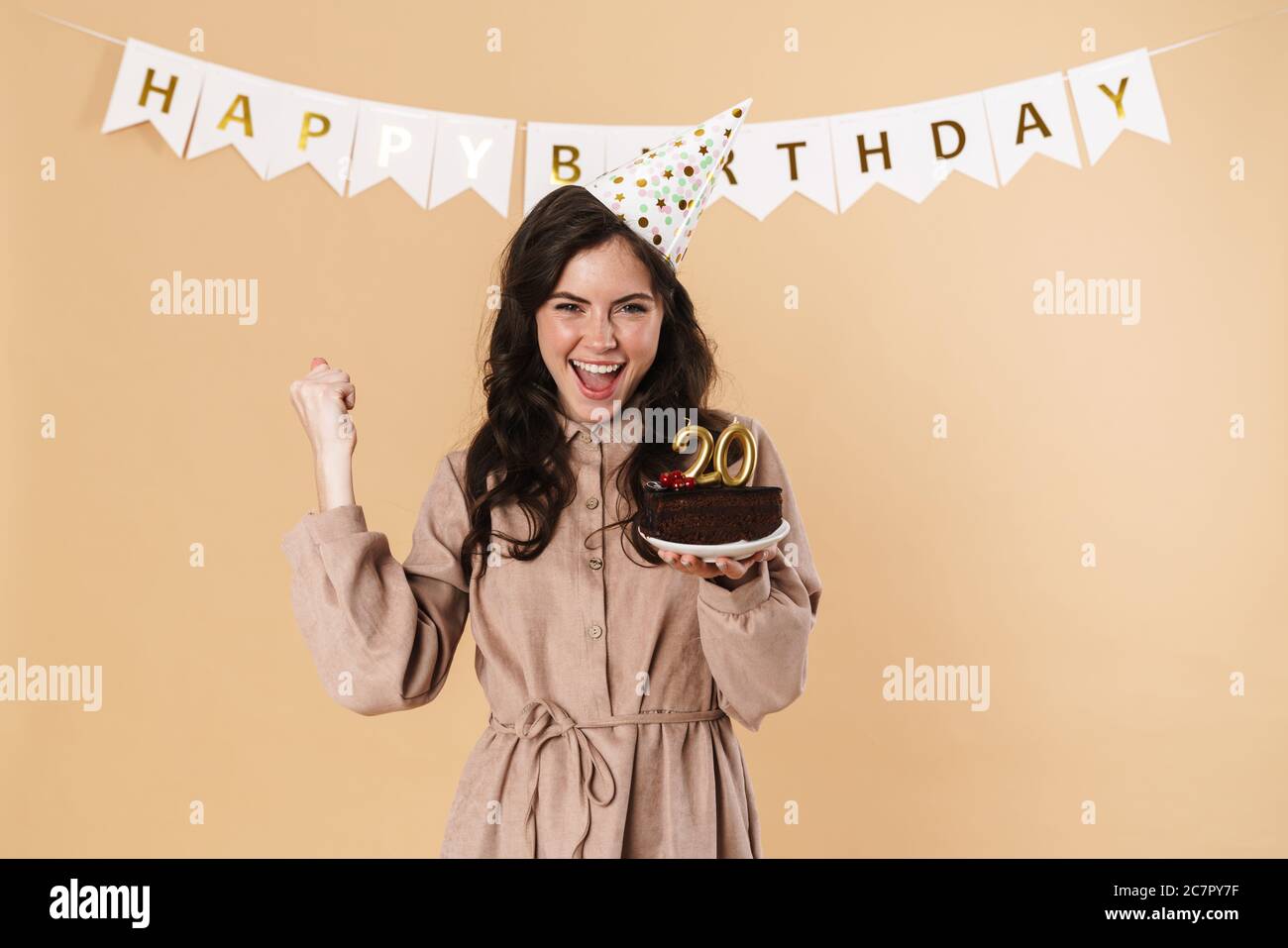 Image of excited woman making winner gesture while posing with birthday ...