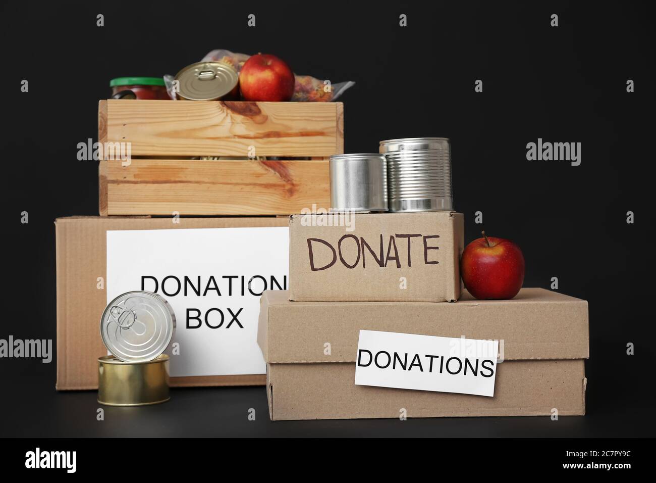 Donation boxes with products on dark background Stock Photo - Alamy