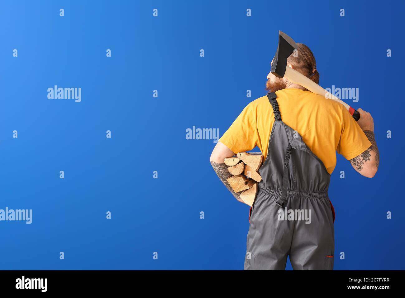 Handsome lumberjack on color background, back view Stock Photo - Alamy