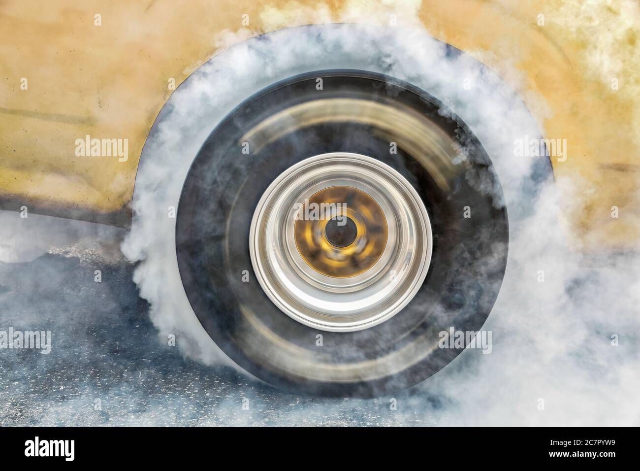 Drag racing car burns rubber off its tires in preparation for the race ...