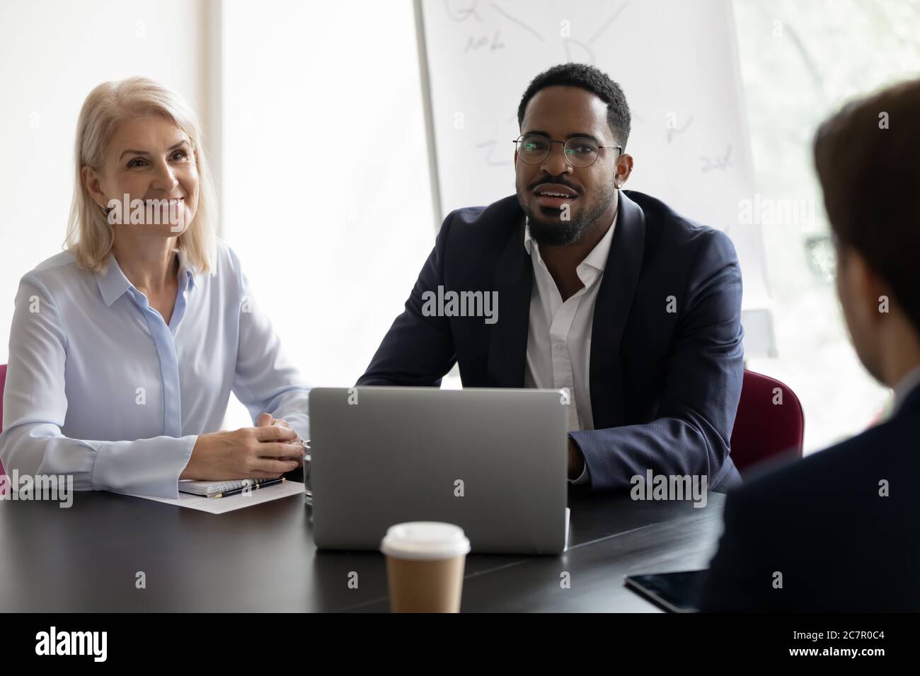 African and mature HR managers listening applicant during job interview ...