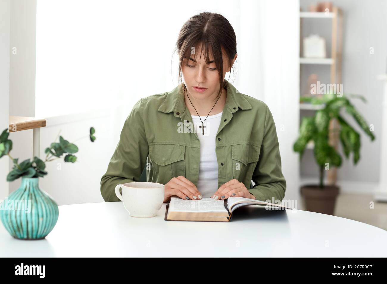 Young woman reading Bible at home Stock Photo - Alamy