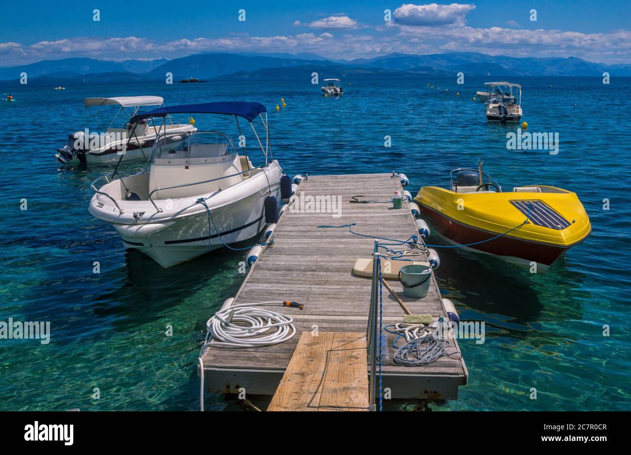Sea lagoon with calm, clear, turquoise water, colorful boats, wooden ...