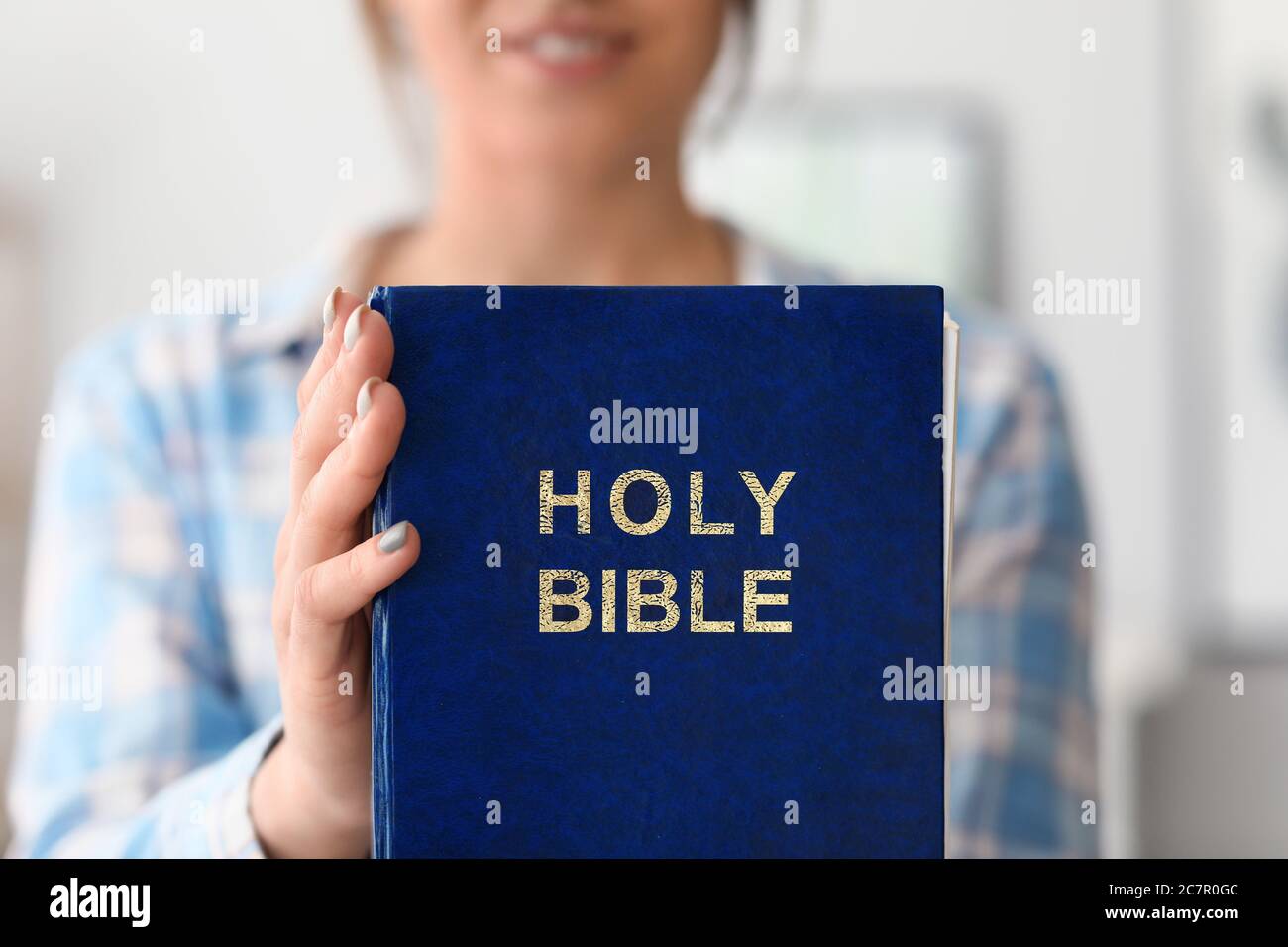 Young woman with Bible at home, closeup Stock Photo - Alamy