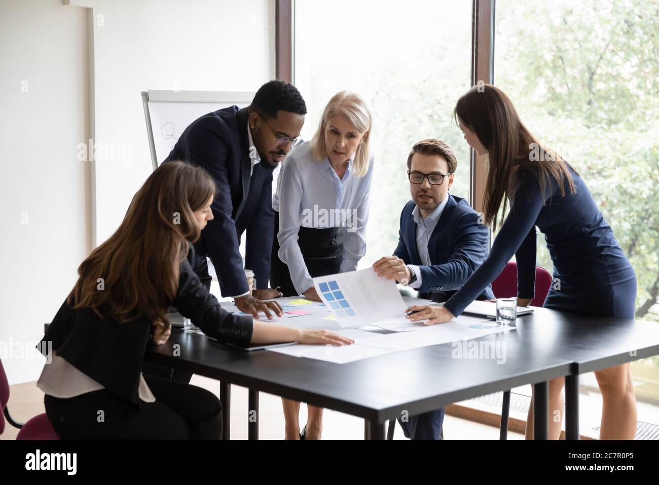 Five diverse employees make project research at group meeting Stock ...