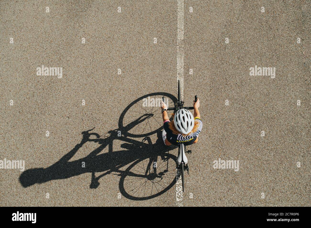 Overhead shot of a woman cycling on a professional bike in a white ...