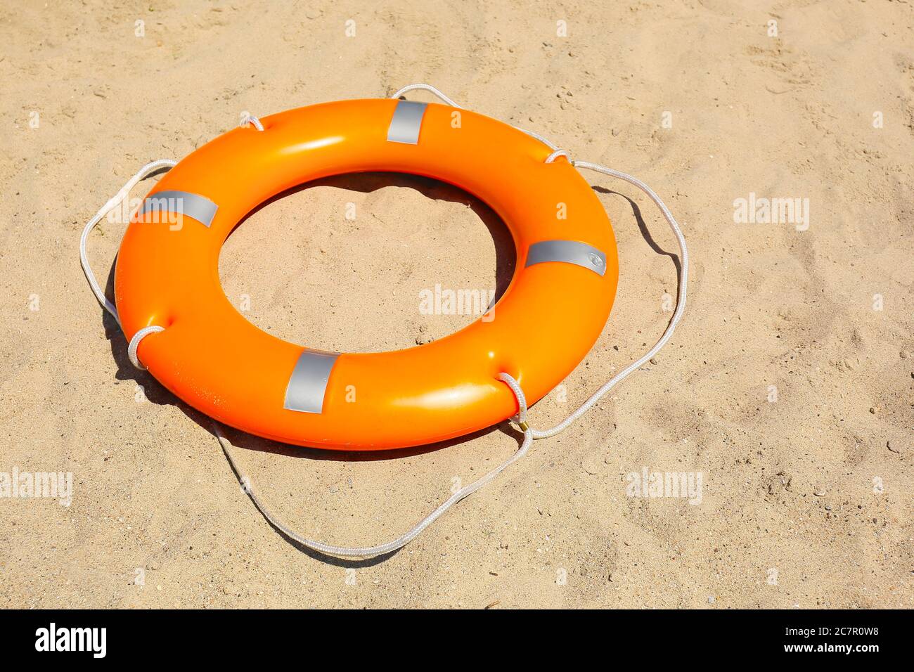 Bright lifebuoy ring on beach Stock Photo - Alamy