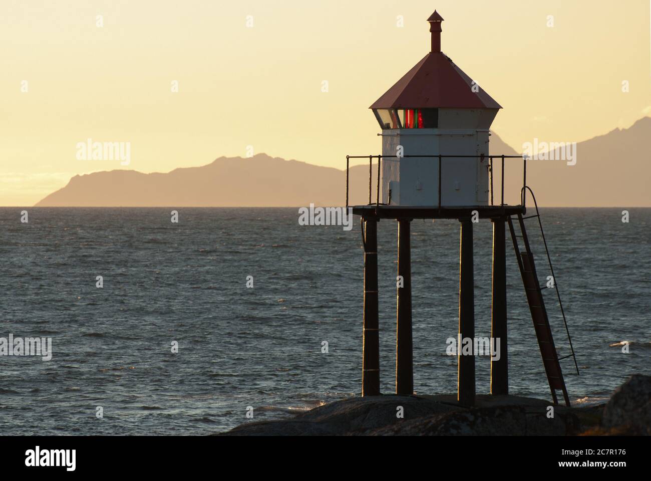 Small lighthouse at the fjord in the light of the midnight sun in the ...