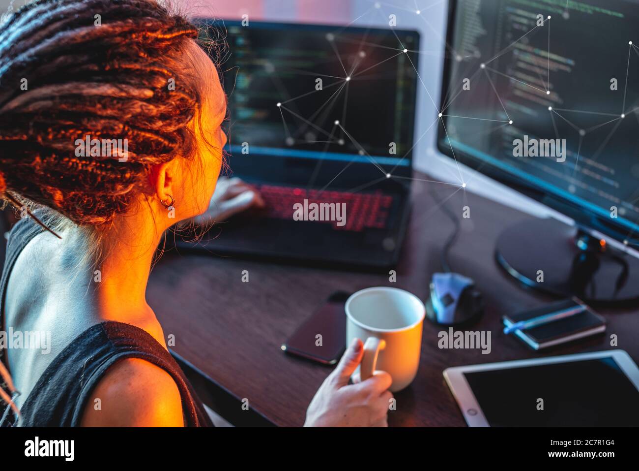 Modern young female programmer is writing program code on a laptop at ...