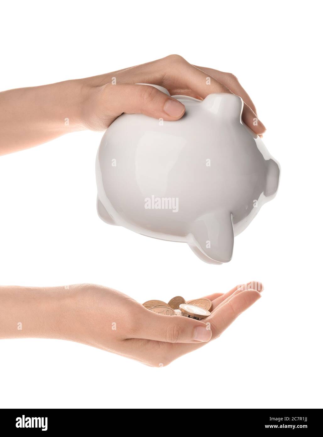 Woman tipping coins from piggy bank on white background Stock Photo - Alamy