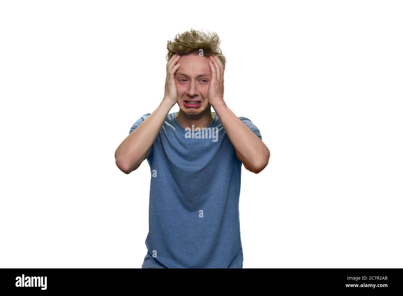 Crying teenage boy is holding his head with both hands Stock Photo - Alamy