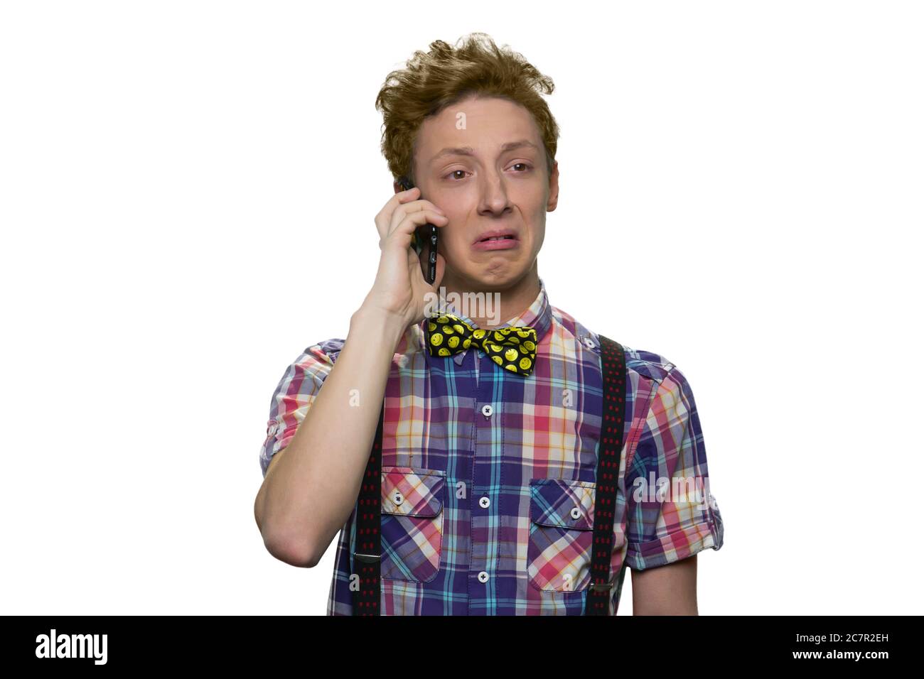 Portrait of teenage boy is talking on phone with facial expression of ...