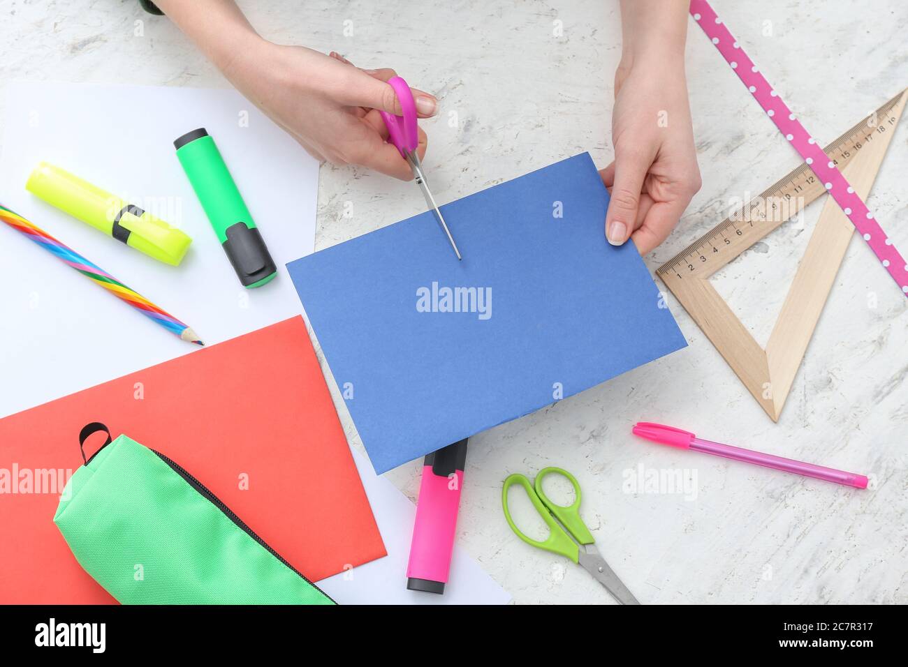 Student cutting paper sheet at table Stock Photo - Alamy