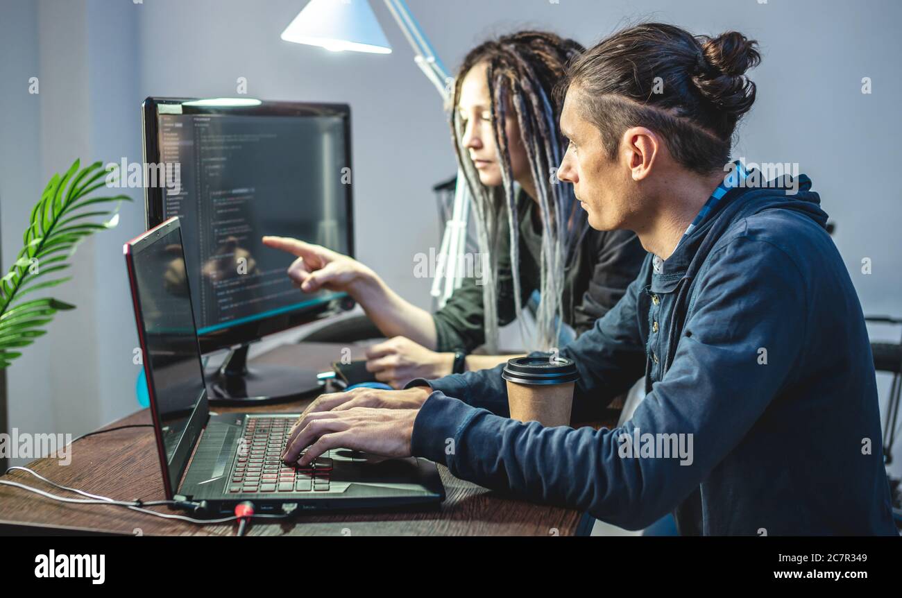 Programmers are developing software by working with software code together. Team work. Modern ...