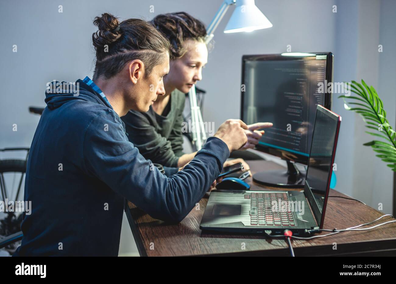 Programmers are developing software by working with software code together. Team work. Modern ...