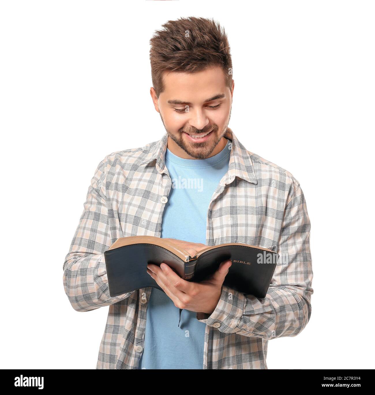 Young man reading Bible on white background Stock Photo - Alamy