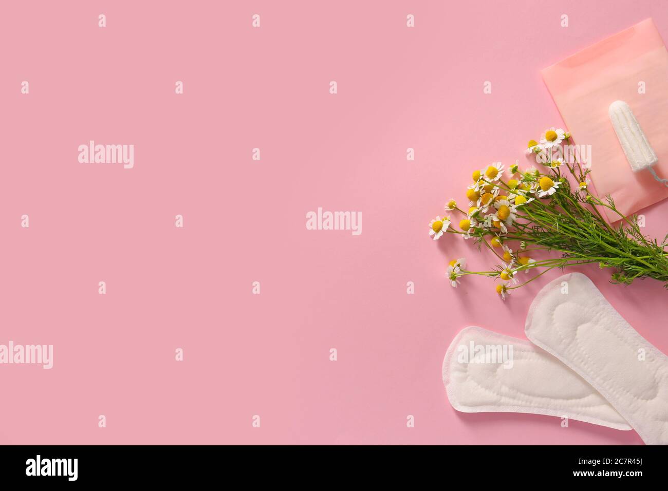 Menstrual pads with tampon and chamomile flowers on color background ...