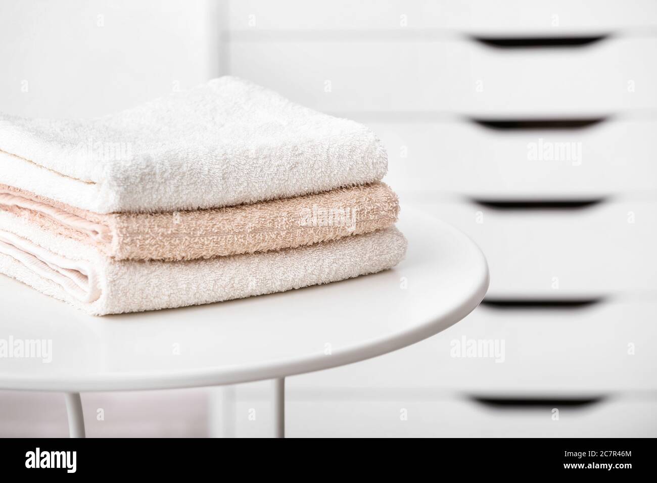 Clean towels on table in bathroom Stock Photo - Alamy