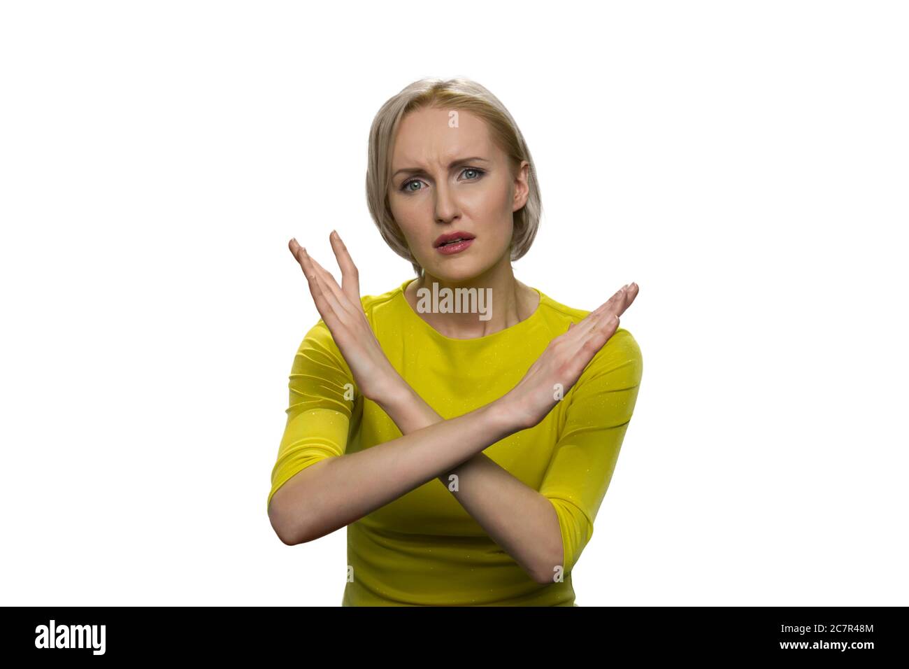 Woman with pleading face making x sign with crossed hands on white ...
