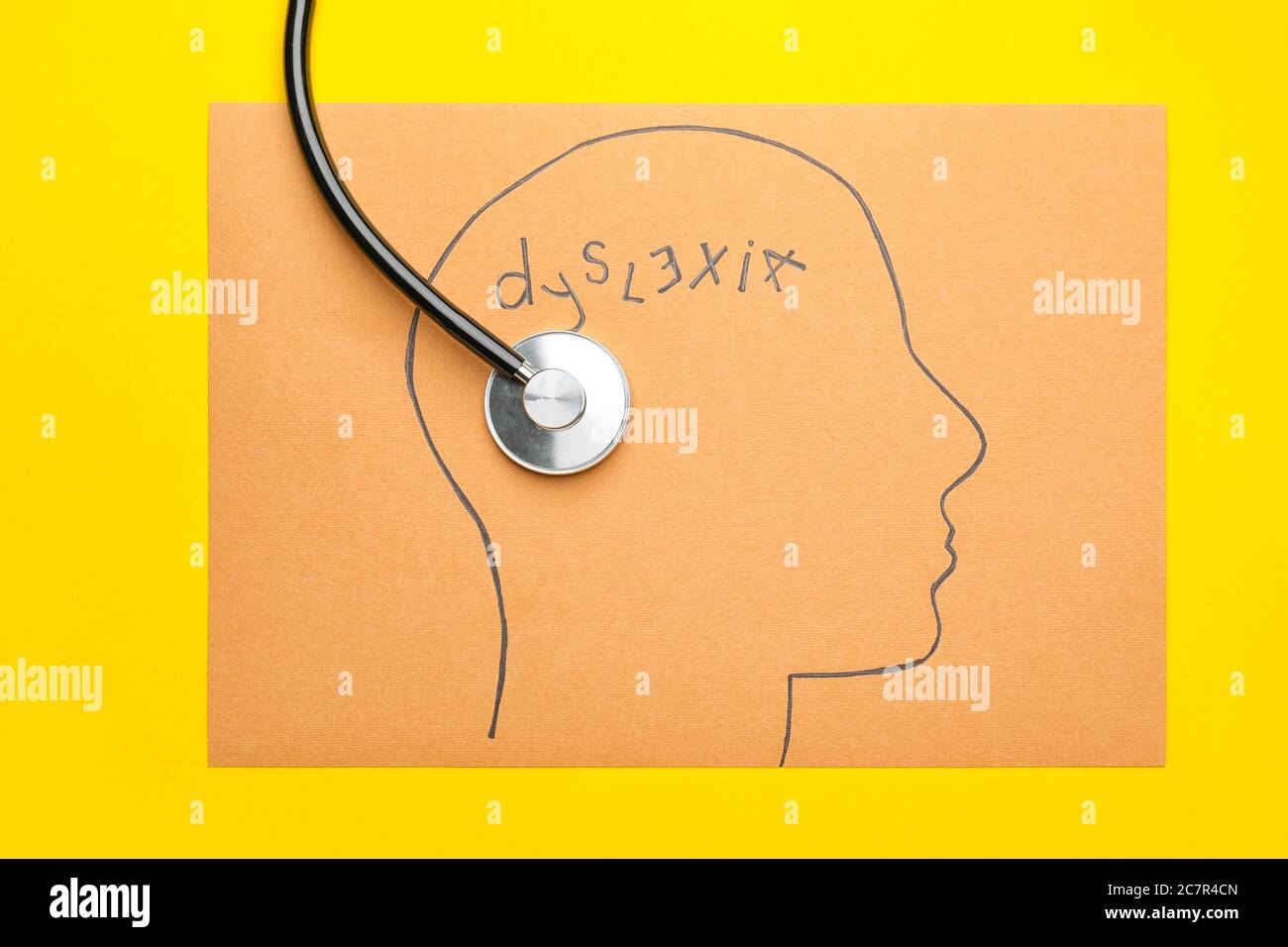 Drawing of human head, stethoscope and word DYSLEXIA on color ...