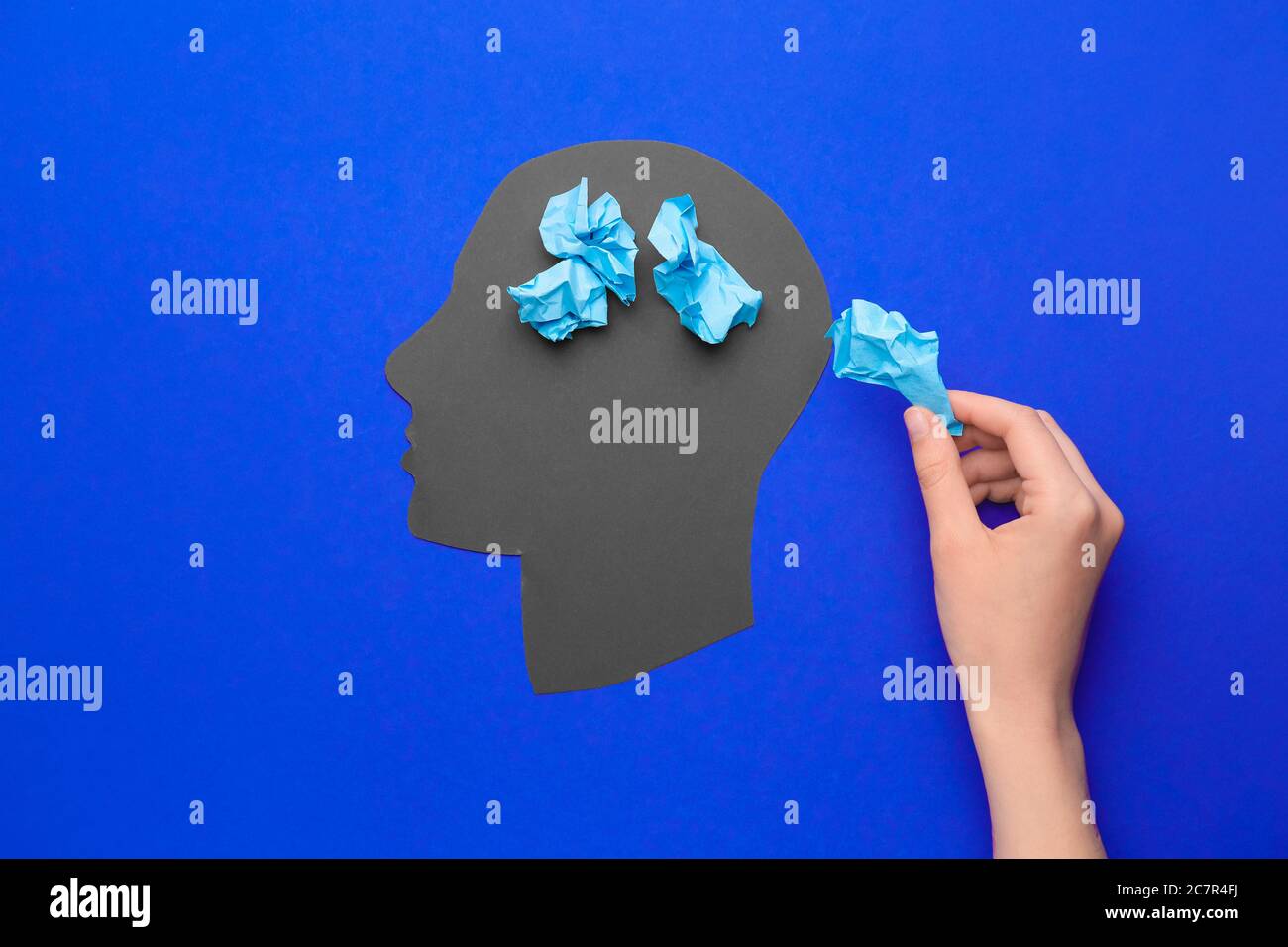 Female hand, human head and crumpled paper pieces on color background ...