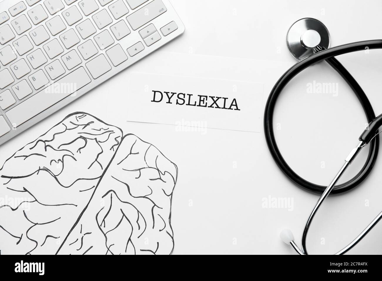 PC keyboard, drawn brain, stethoscope and word DYSLEXIA on white ...