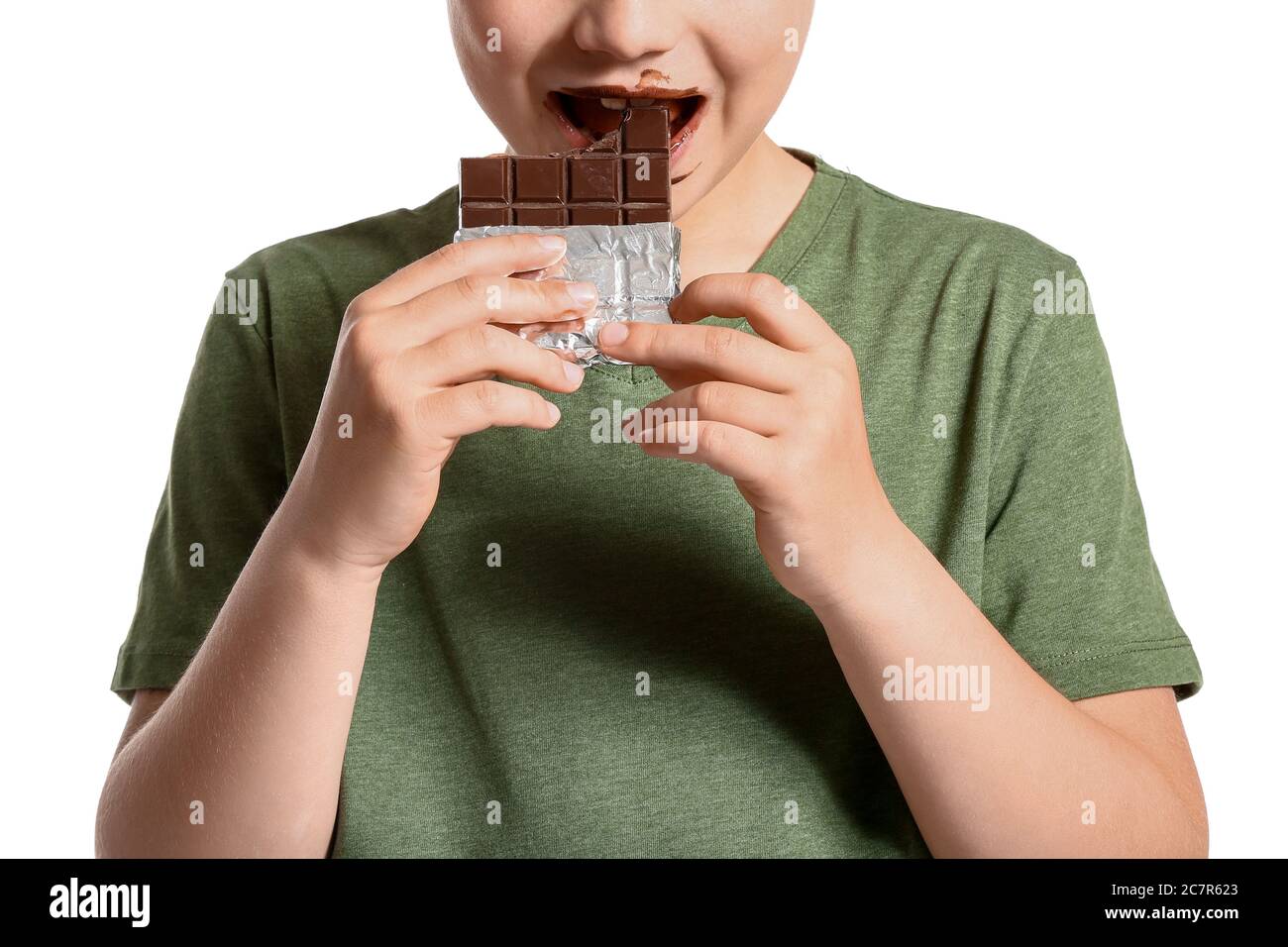 Cute little boy eating chocolate on white background Stock Photo - Alamy
