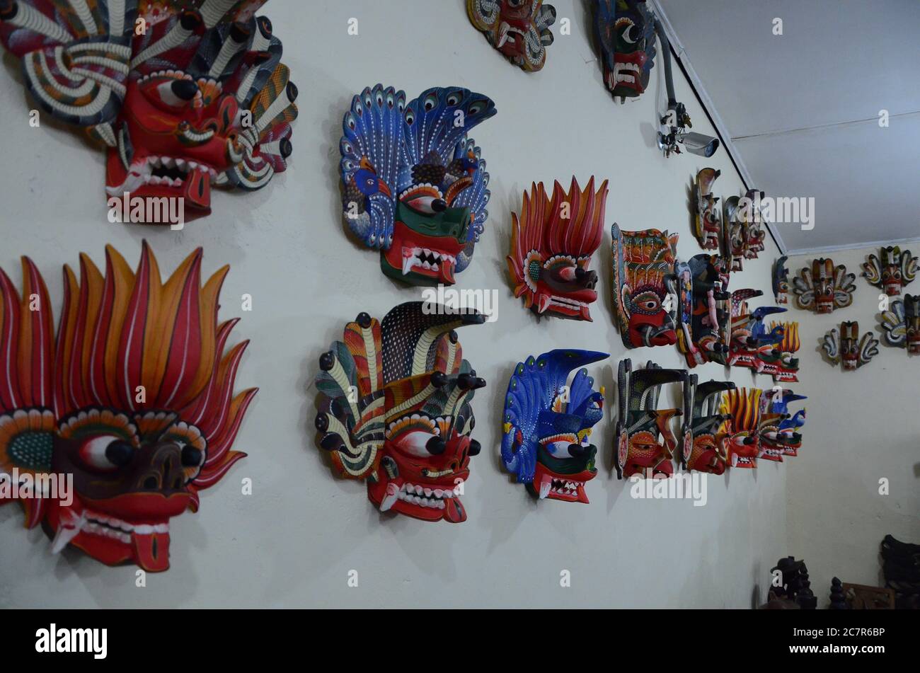 Weird-looking wooden masks shaped like a human face on a white wall ...