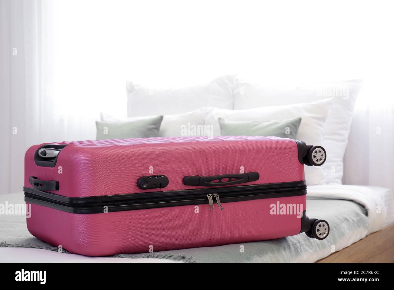 Suitcase on bed in hotel room Stock Photo - Alamy