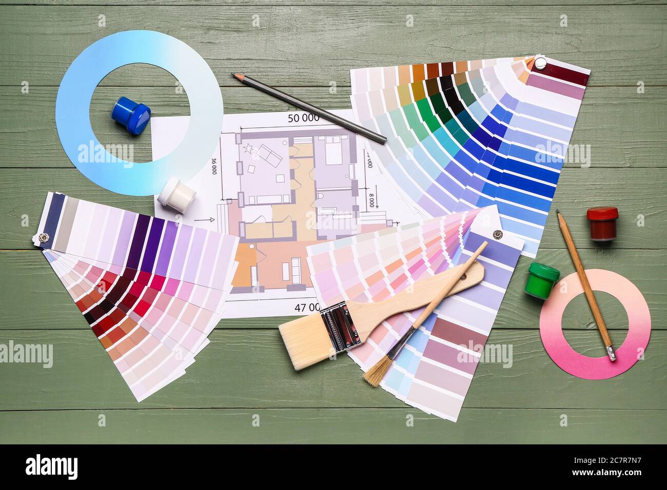Color palettes with building plan and paint brushes on wooden ...