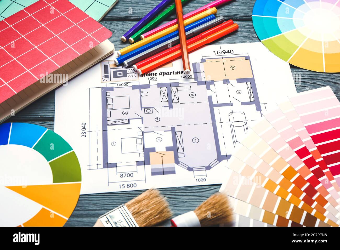 Color palettes with building plan and paint brushes on wooden ...