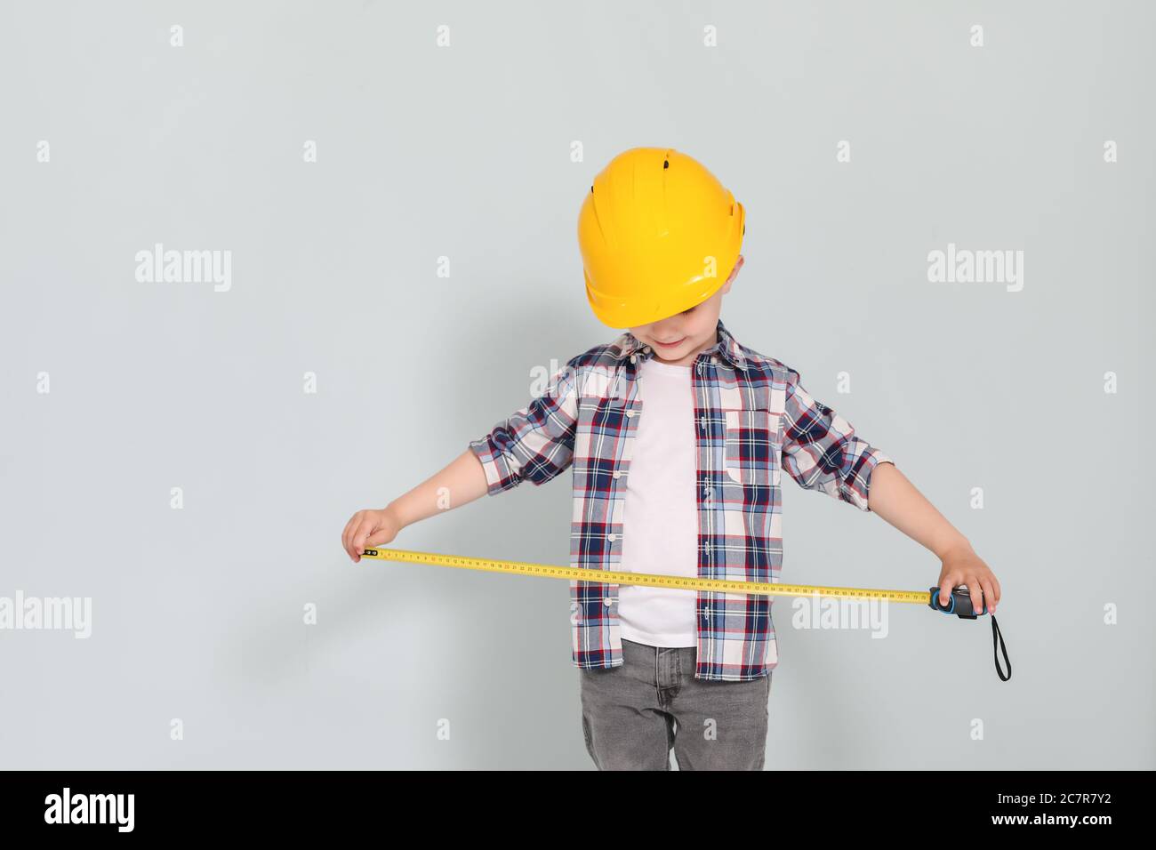 Little boy with measuring tape on grey background Stock Photo - Alamy