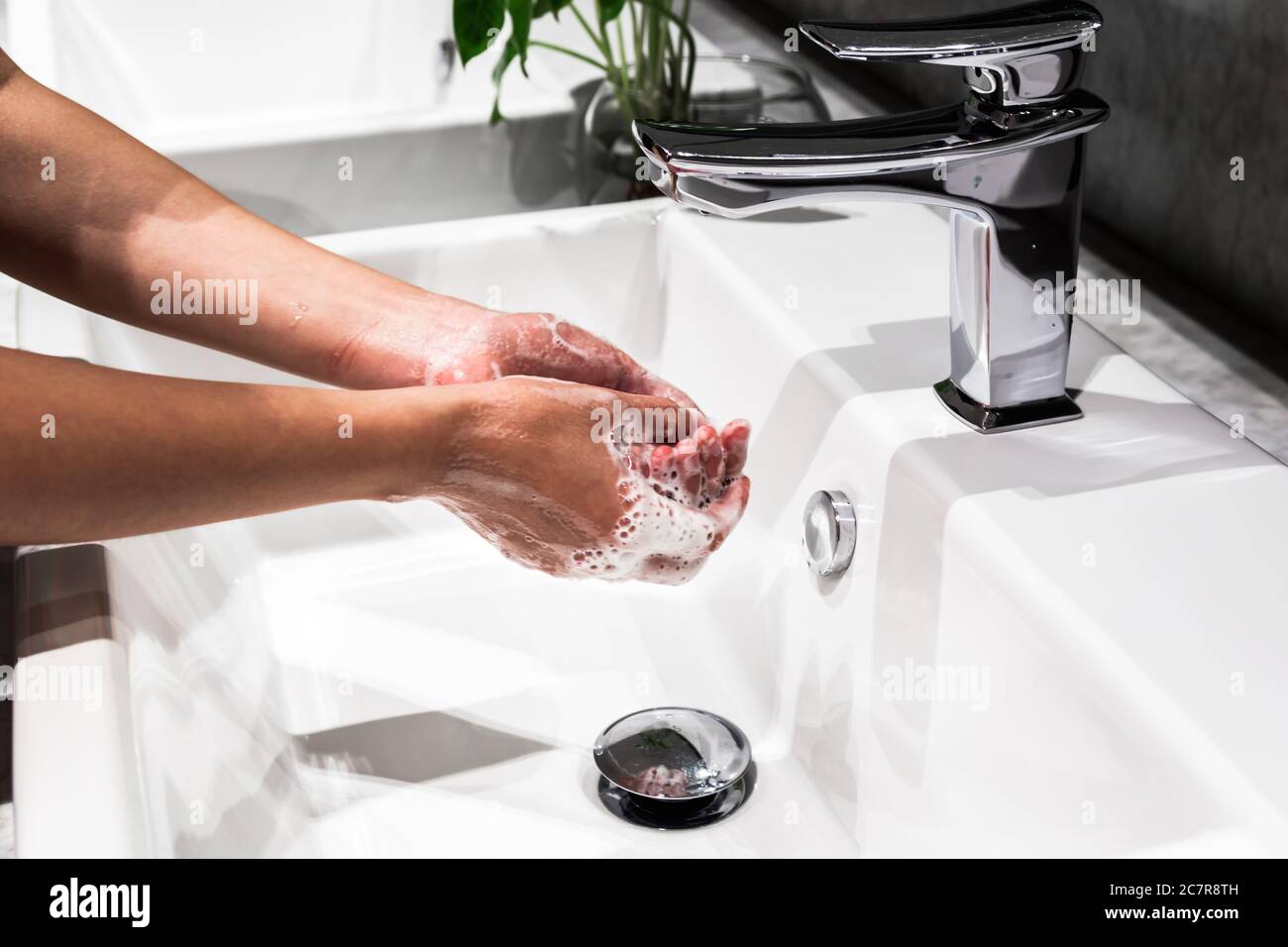 Young asian women washing hand with soap in faucet. New normal ...