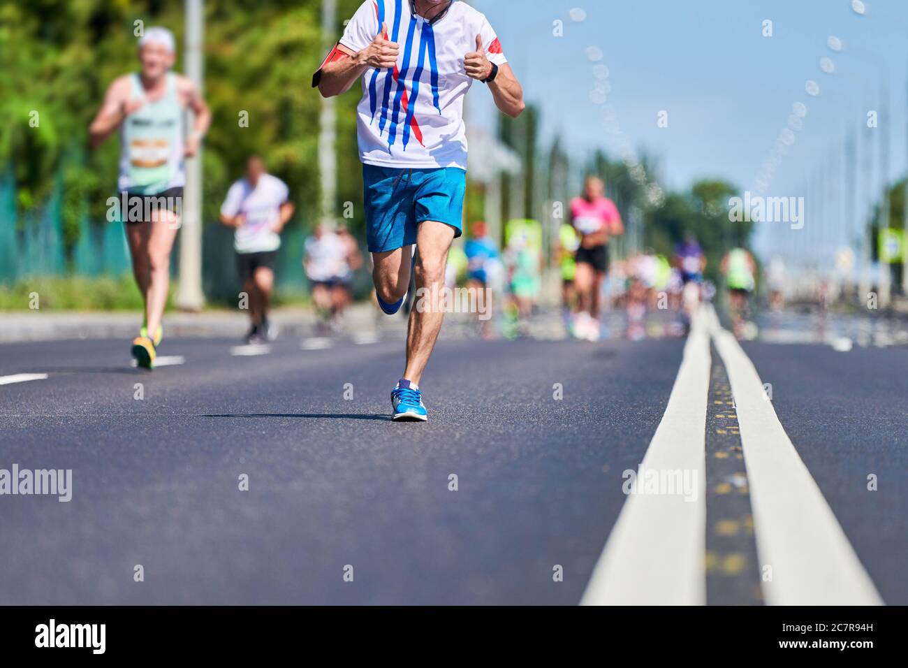 Marathon runners on city road. Running competition. Street sprinting ...